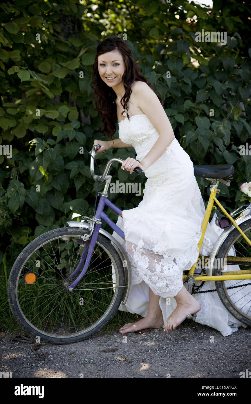 Bride in white wedding dress on retro bicycle Stock Photo - Alamy