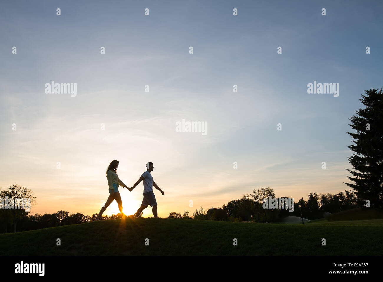 Lovers walk holding by hands Stock Photo - Alamy