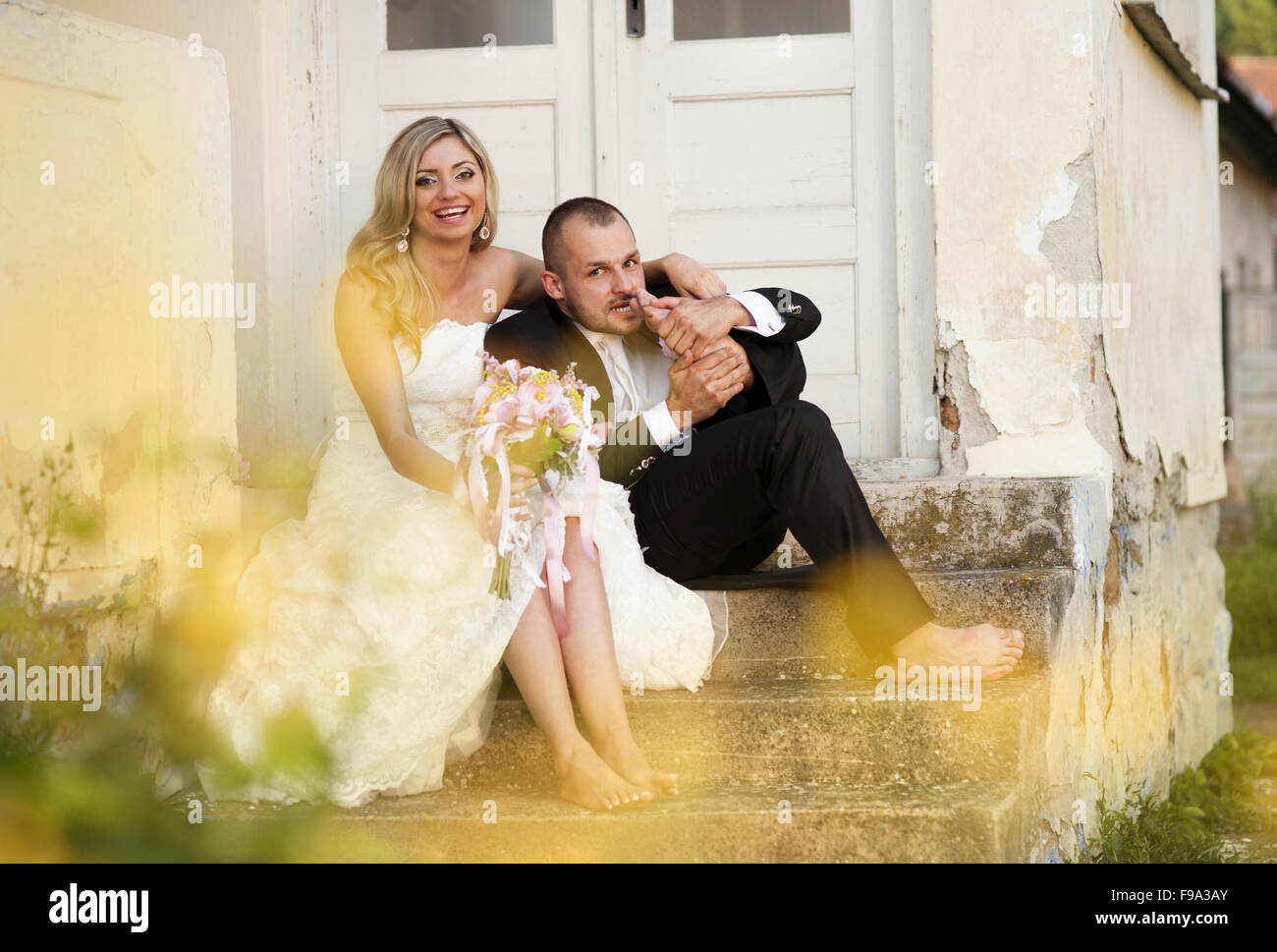 Happy bride and groom posing by the old house Stock Photo - Alamy