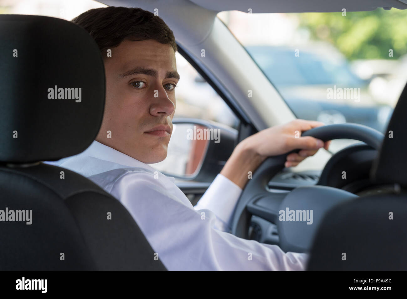 The young man behind the wheel driving car Stock Photo - Alamy