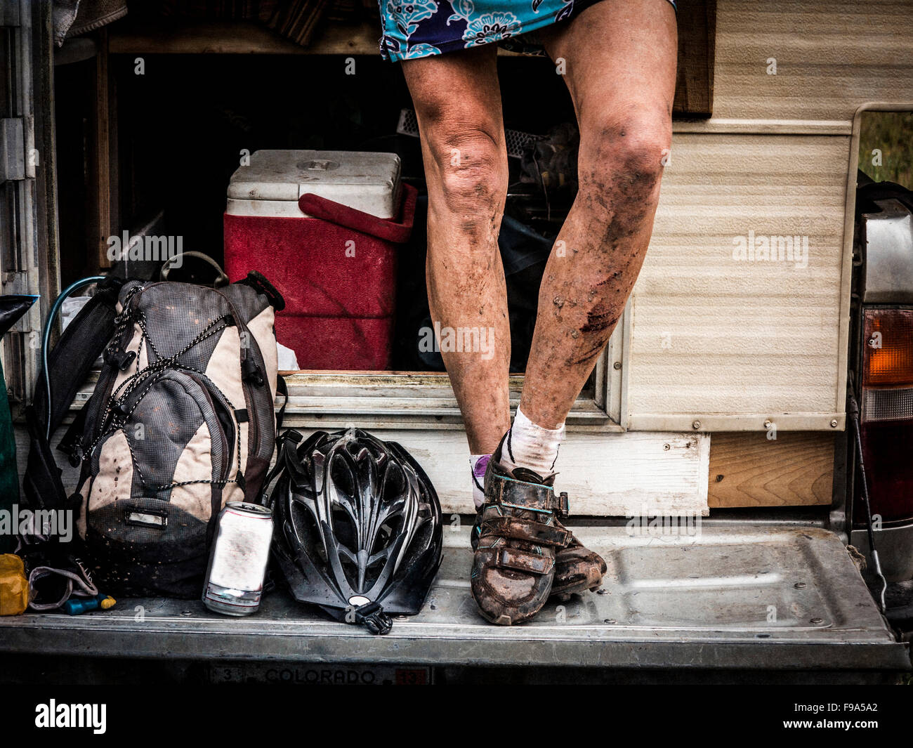 A scraped up and muddy woman standing on the tailgate of a truck after ...