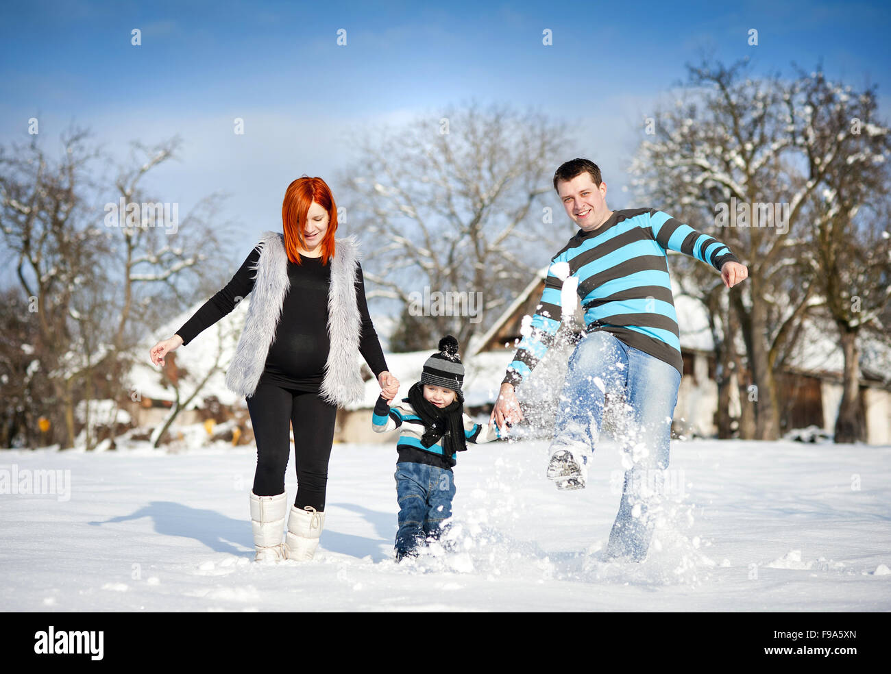 Happy parents with child having fun outside in snow Stock Photo - Alamy