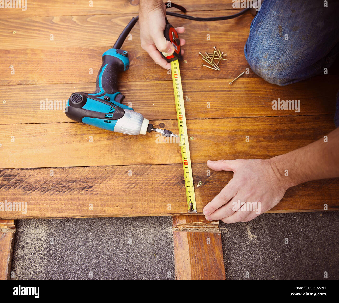 Close up of male hands measuring wood flooring with tape measure Stock ...