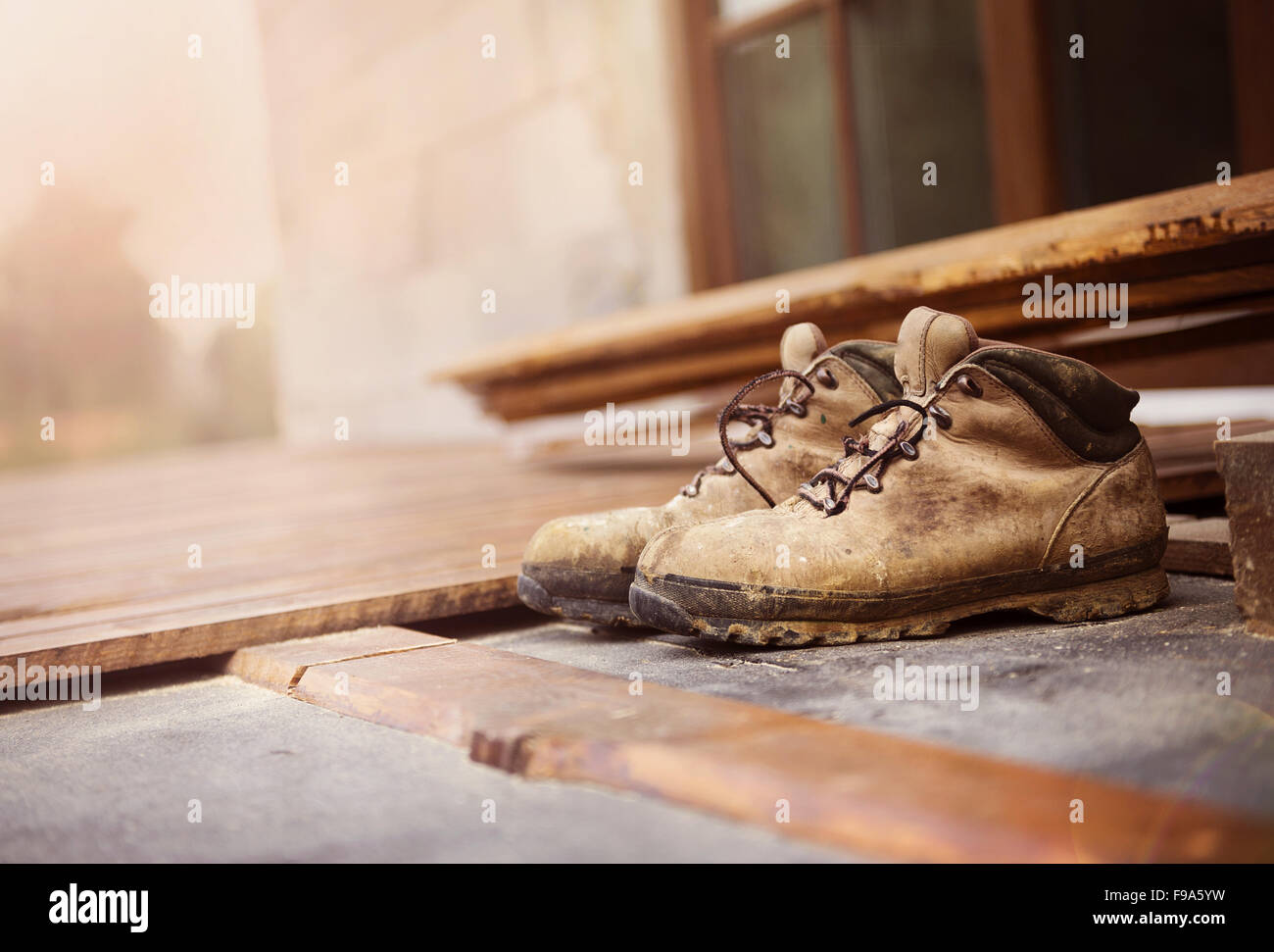 Old worker boots left on unfinished patio wooden flooring Stock Photo ...
