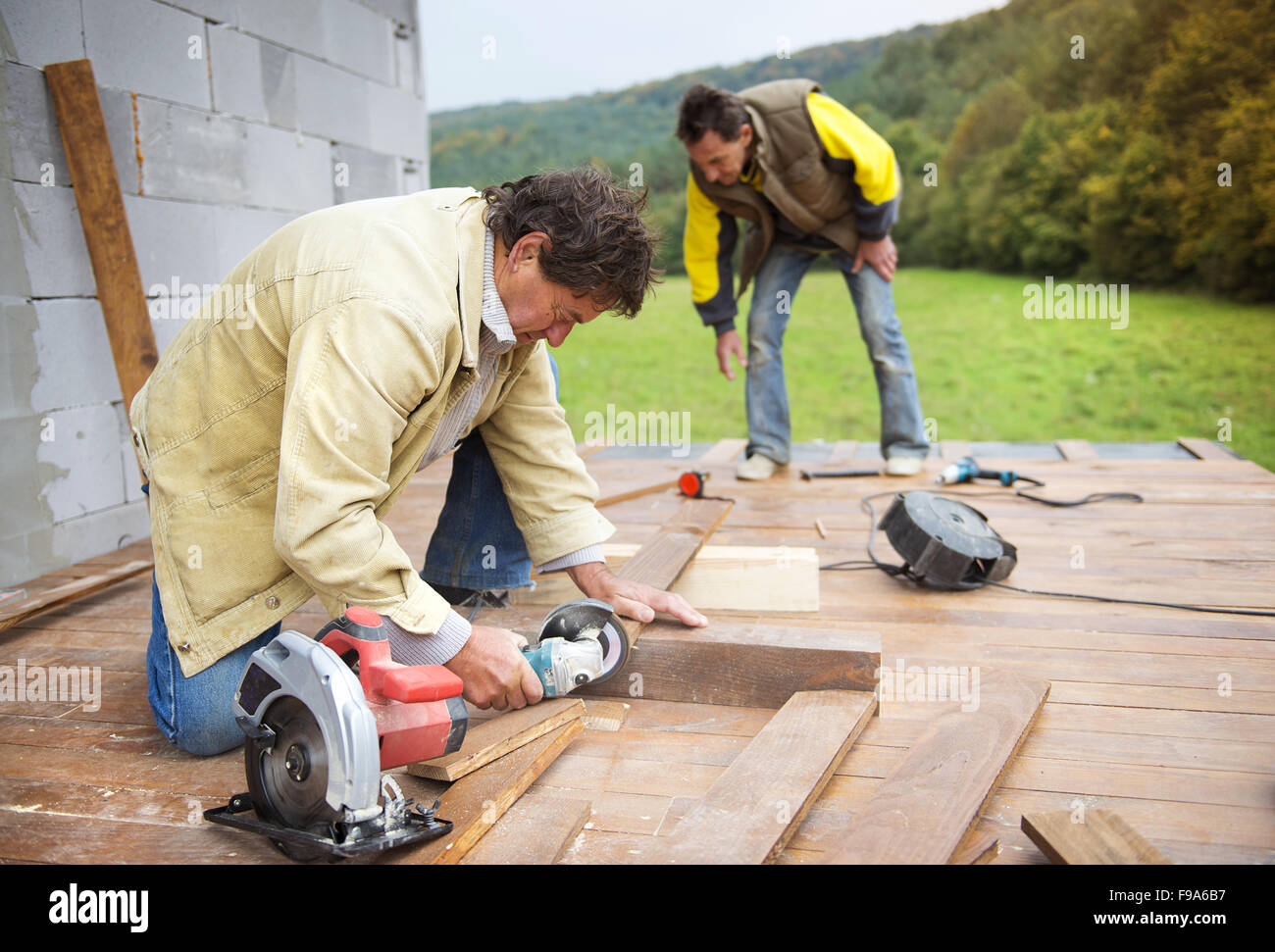 Two carpenters grinding wooden planks outside in terrace Stock Photo ...
