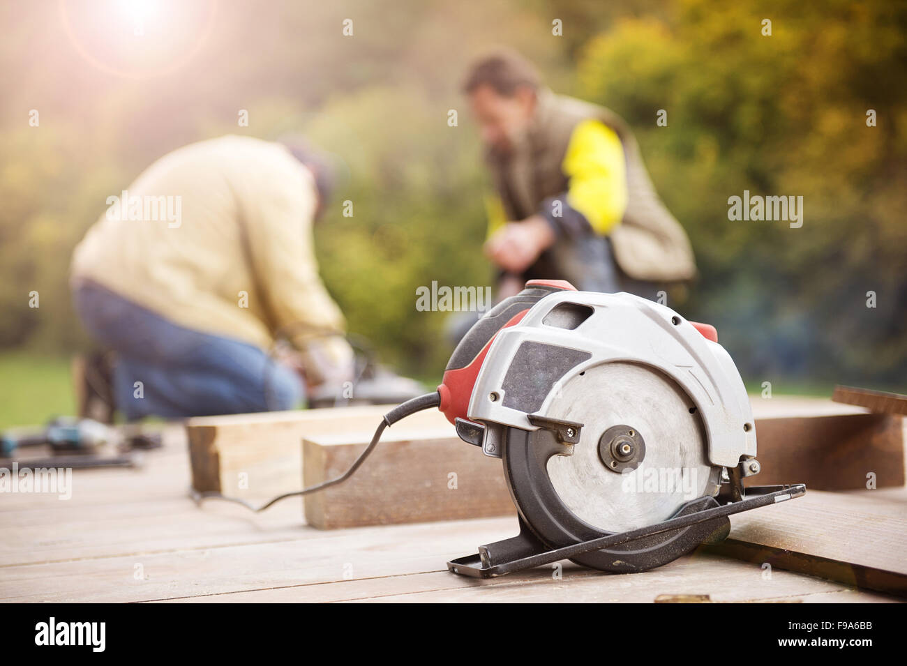 Two carpenters grinding wooden planks outside in terrace Stock Photo ...