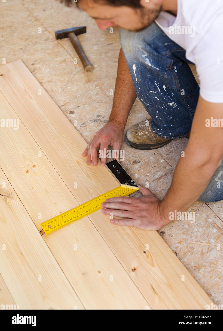 Close up of male hands measuring wood flooring Stock Photo - Alamy