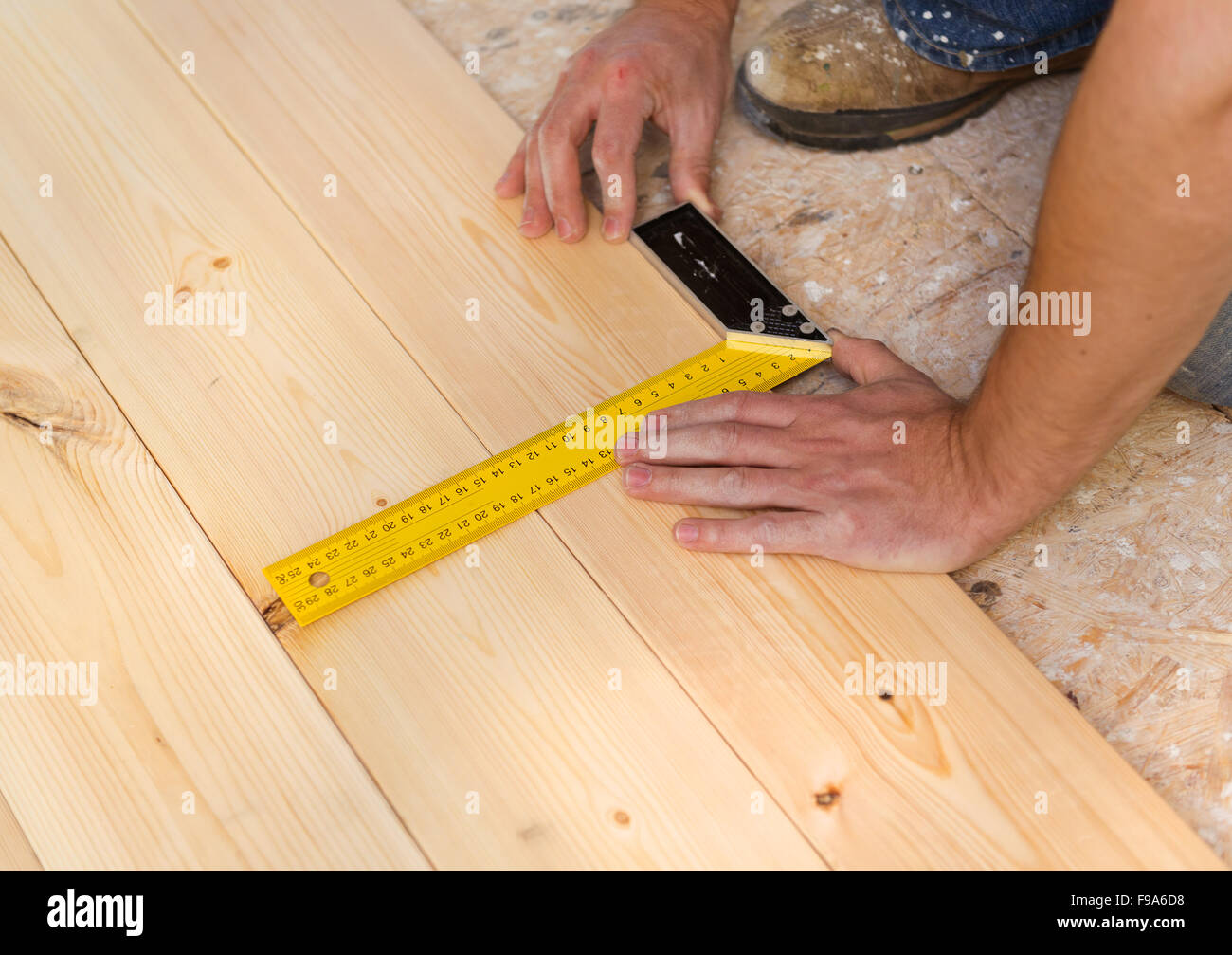 Close up of male hands measuring wood flooring Stock Photo - Alamy