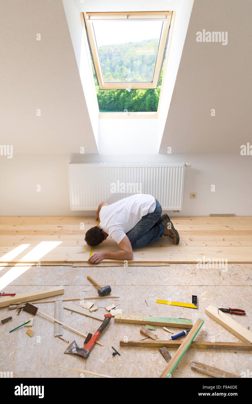 Handyman installing wooden floor in new house Stock Photo - Alamy