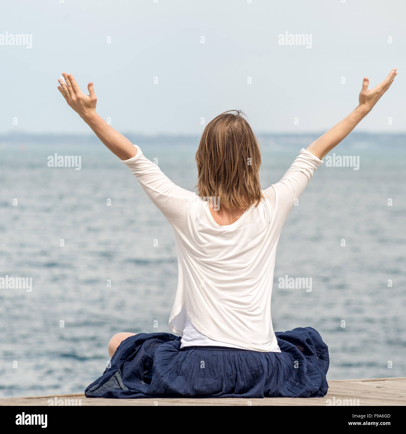 Woman meditating at the sea Stock Photo - Alamy