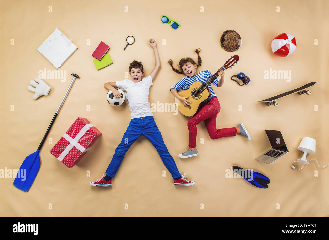 Funny children are playing together. Lying on the floor with guitar and ...