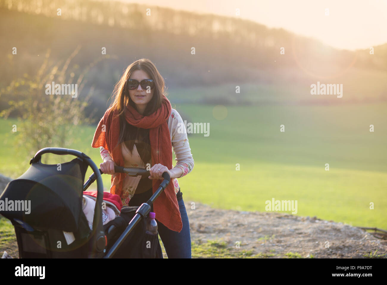 Happy young mother with pram during the walk in nature Stock Photo - Alamy