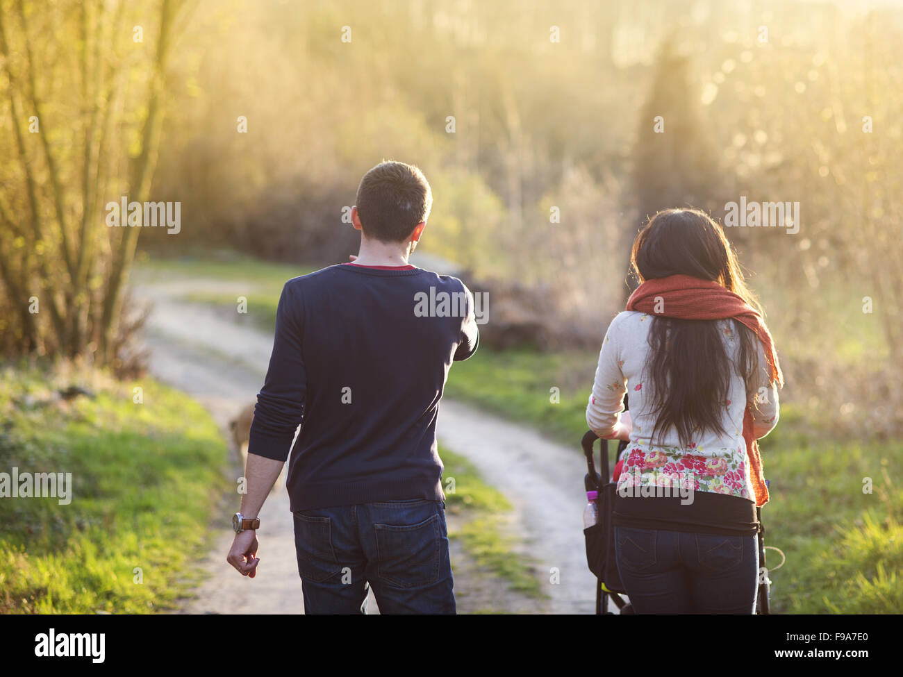 Happy and young family with pram during the walk in nature Stock Photo ...