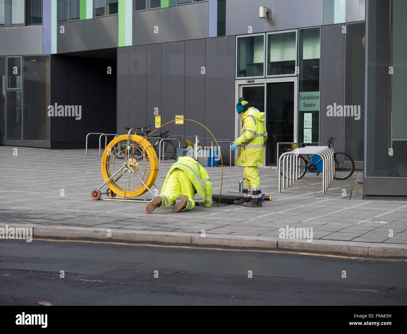 two engineers in yellow hi vis suits working down manhole Sheffield ...