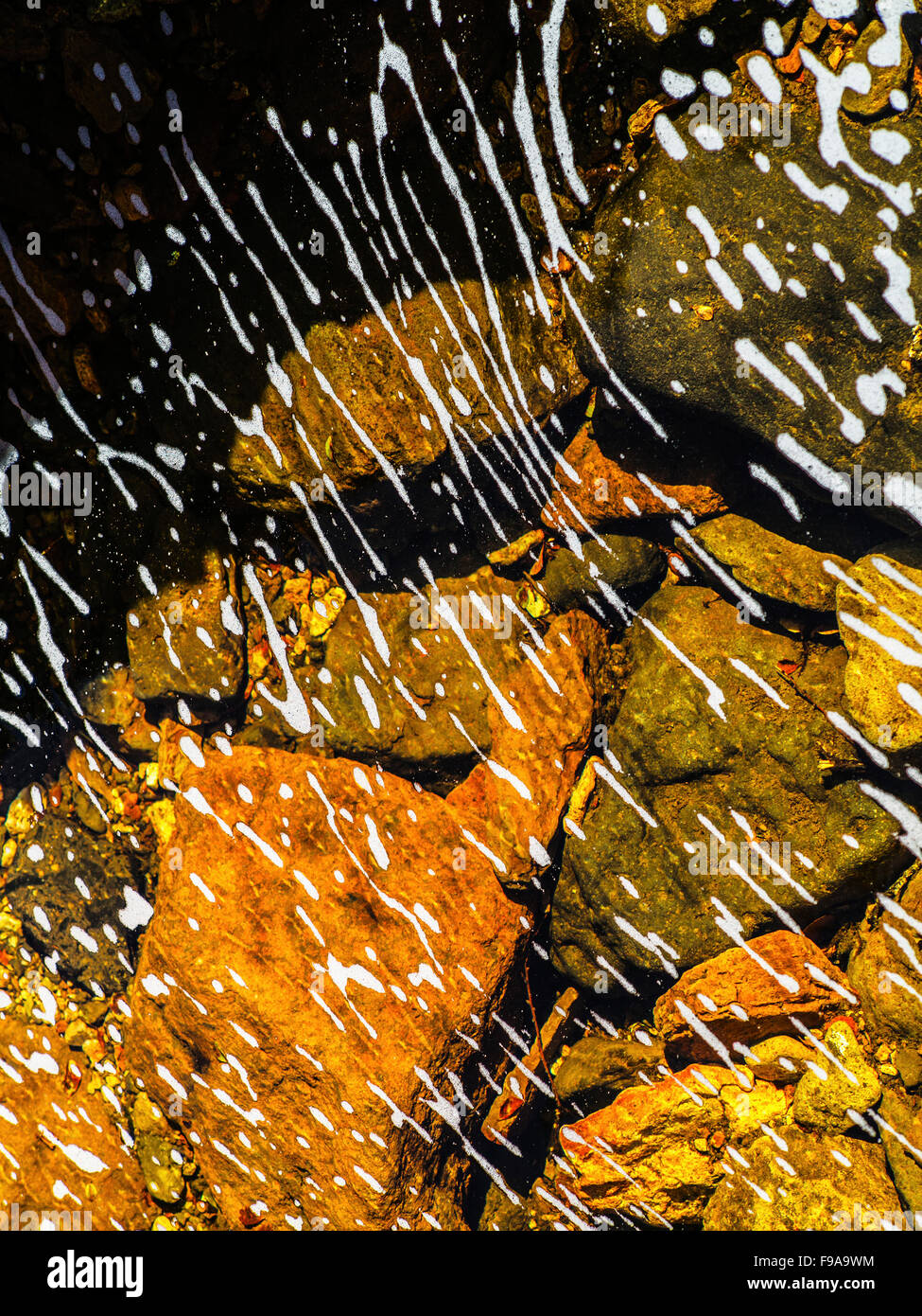 Foam on top colorful rocks underwater Stock Photo - Alamy