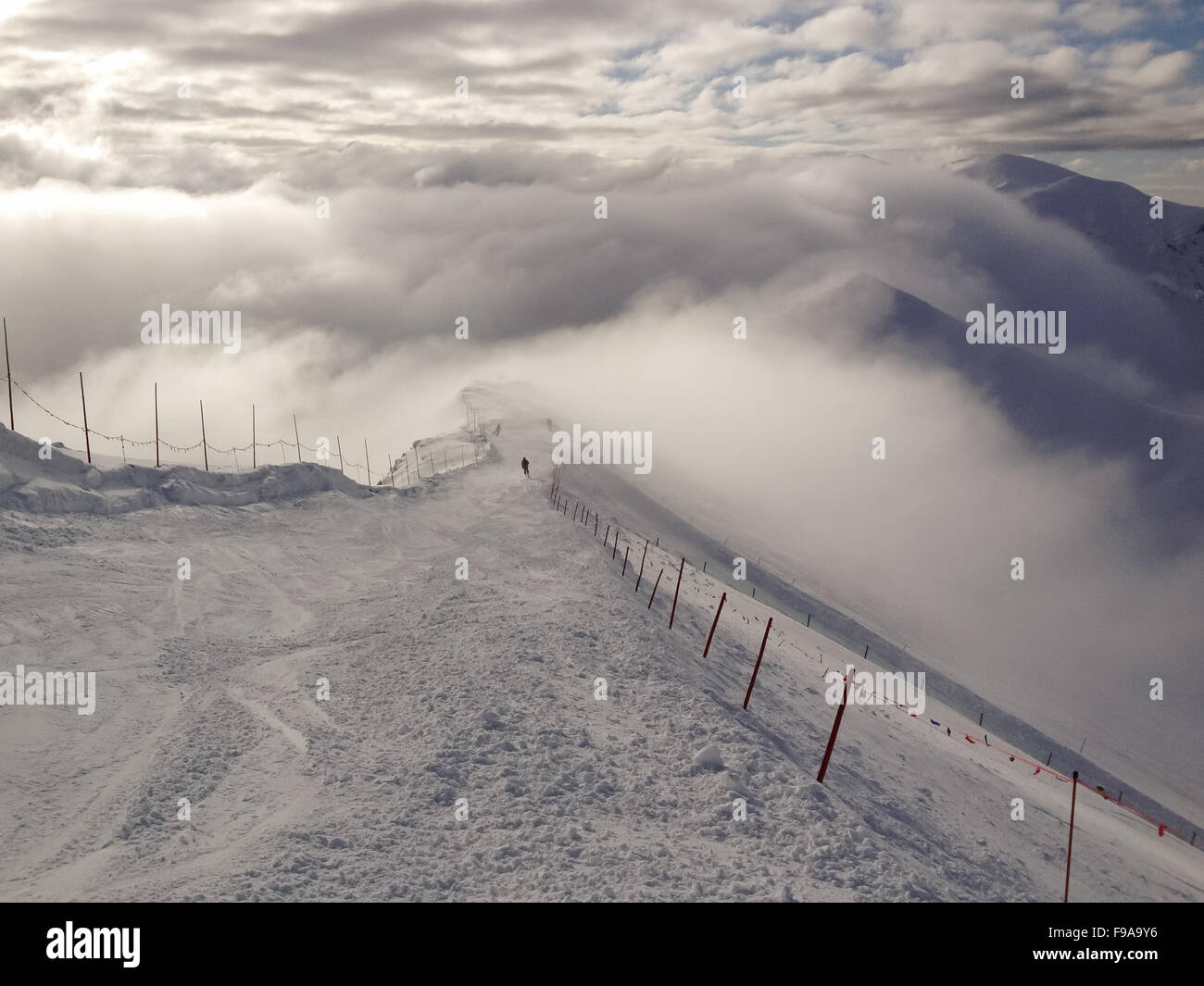 Ski slope on a mountainridge where the clouds are passing by. Kasprowy ...