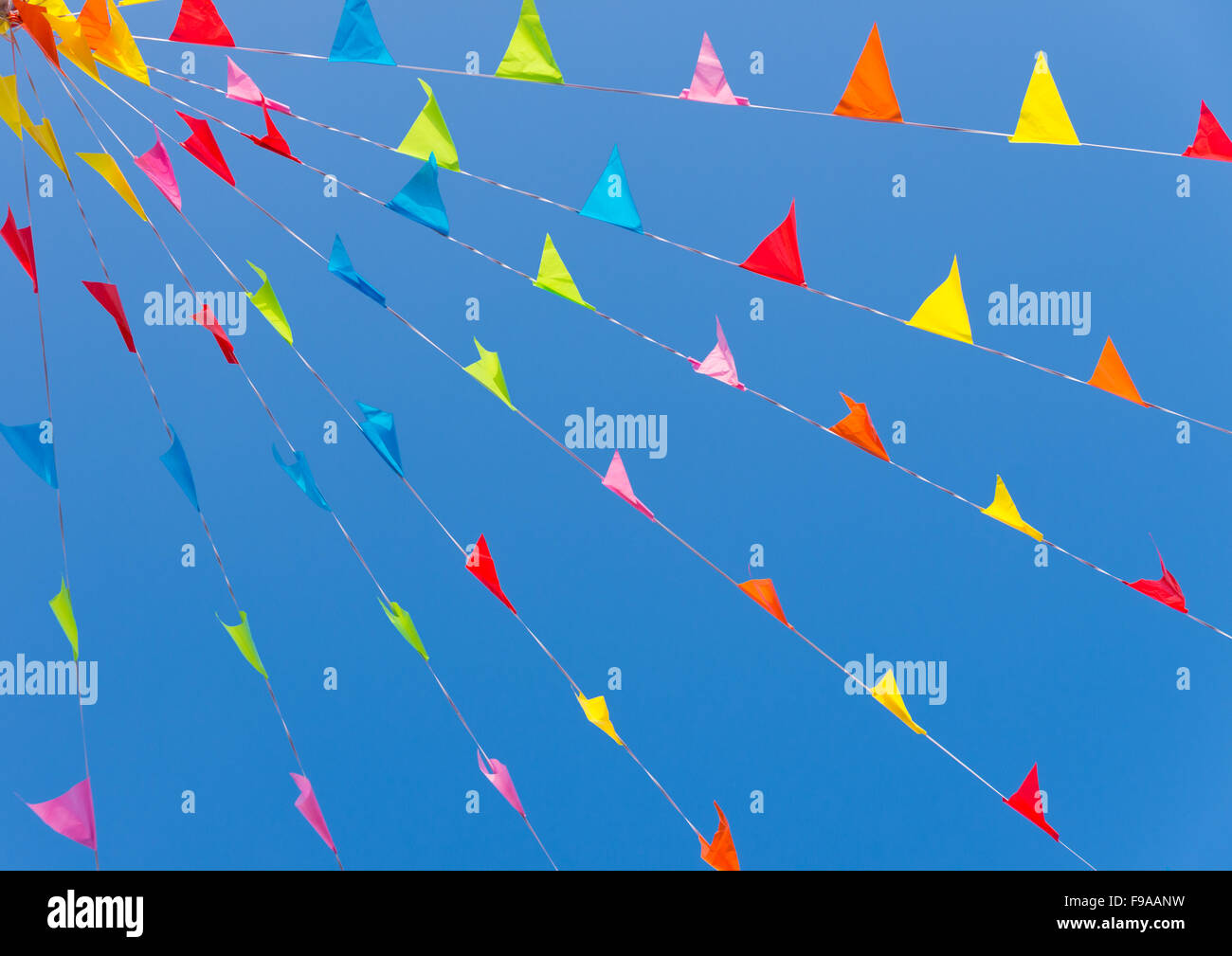 colorful bunting flags against a blue saturated sky Stock Photo - Alamy