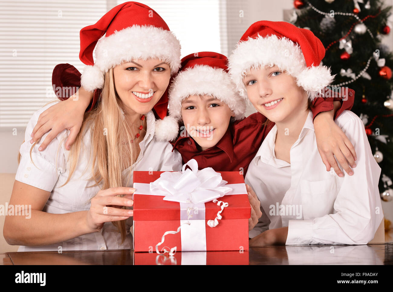 Mom and children in santa hats Stock Photo - Alamy