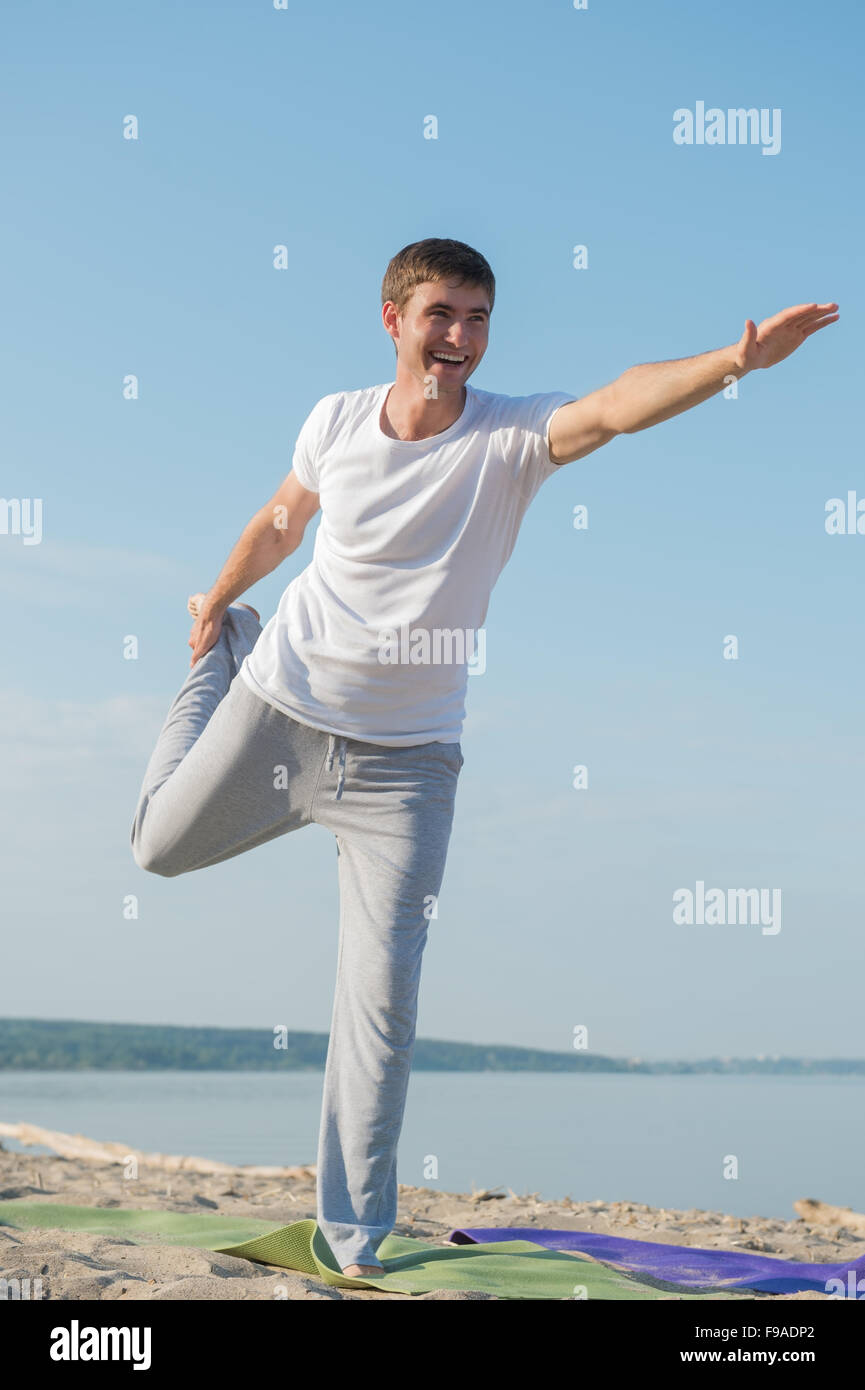 Man practicing yoga against a sea background Stock Photo - Alamy