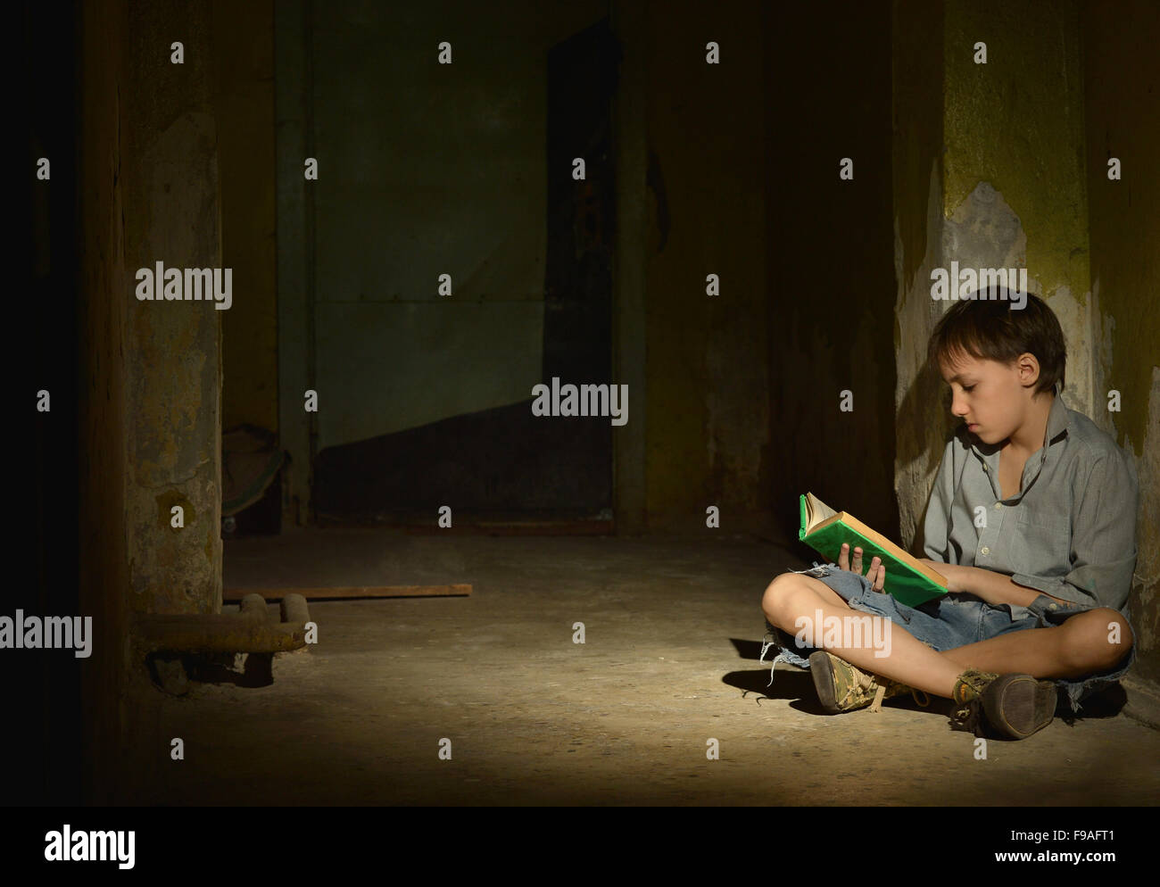 Lonely little boy reading book Stock Photo - Alamy