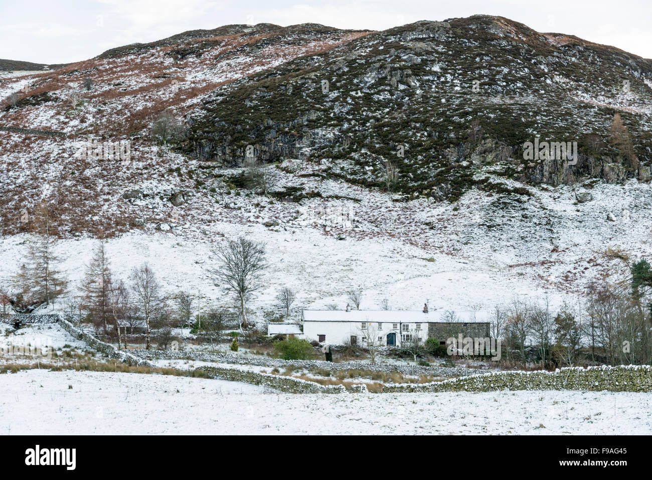 A snowy landscape of Cumbrian farms, buildings and mountains near ...