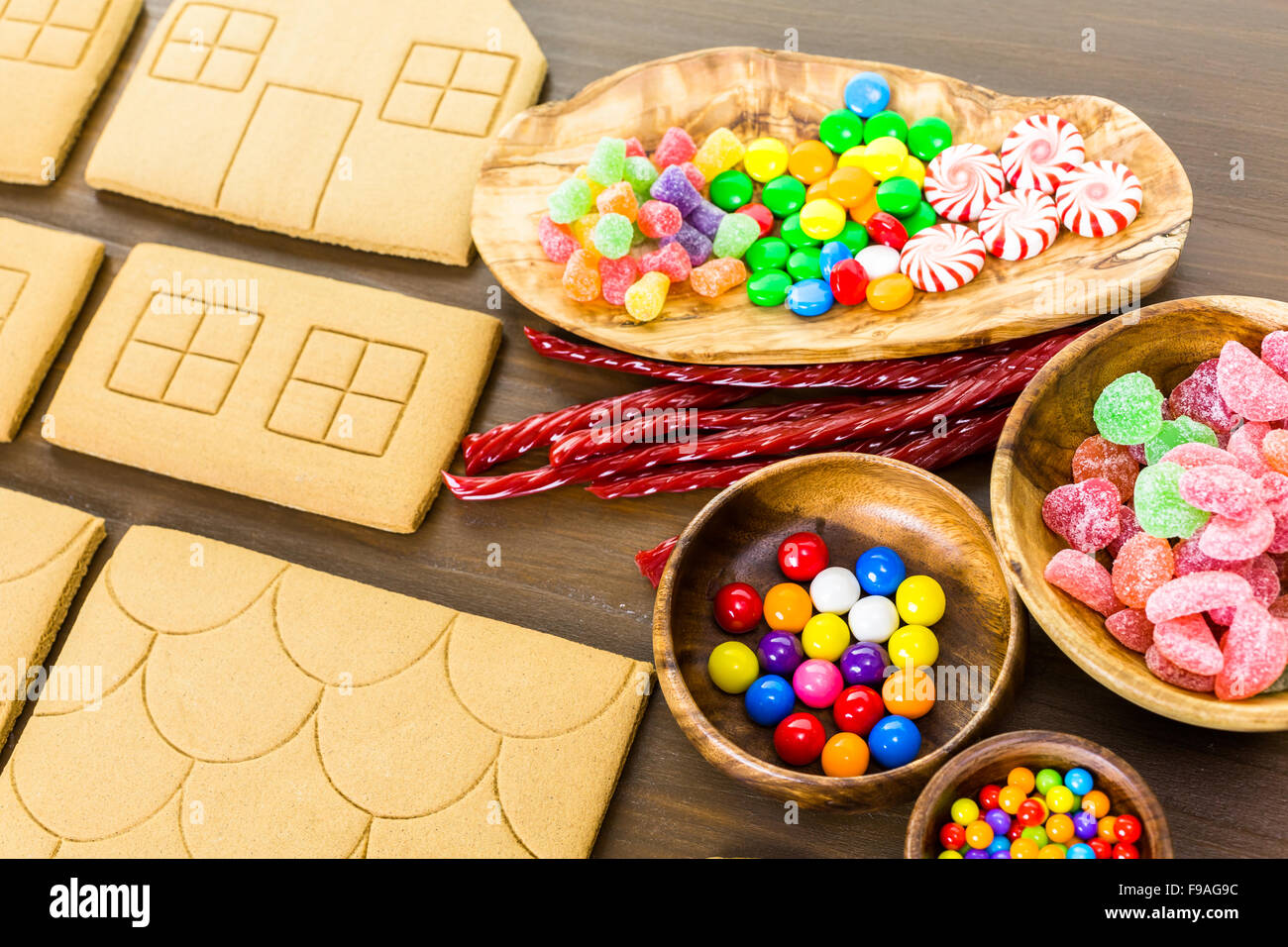 Decorating gingerbread house with royal icing and colorful candies ...