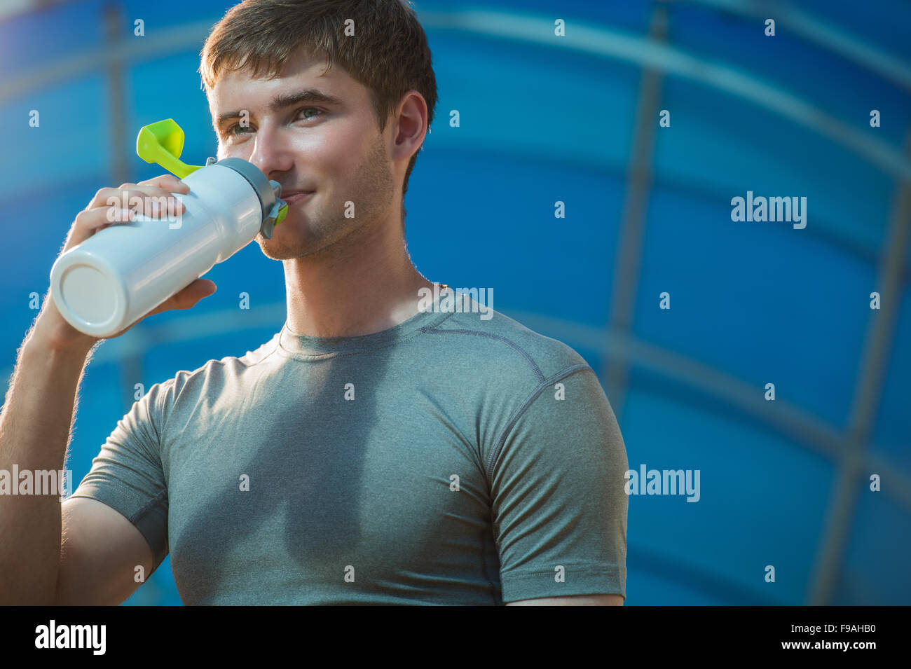 Athletic young man drinking water after hard training Stock Photo - Alamy