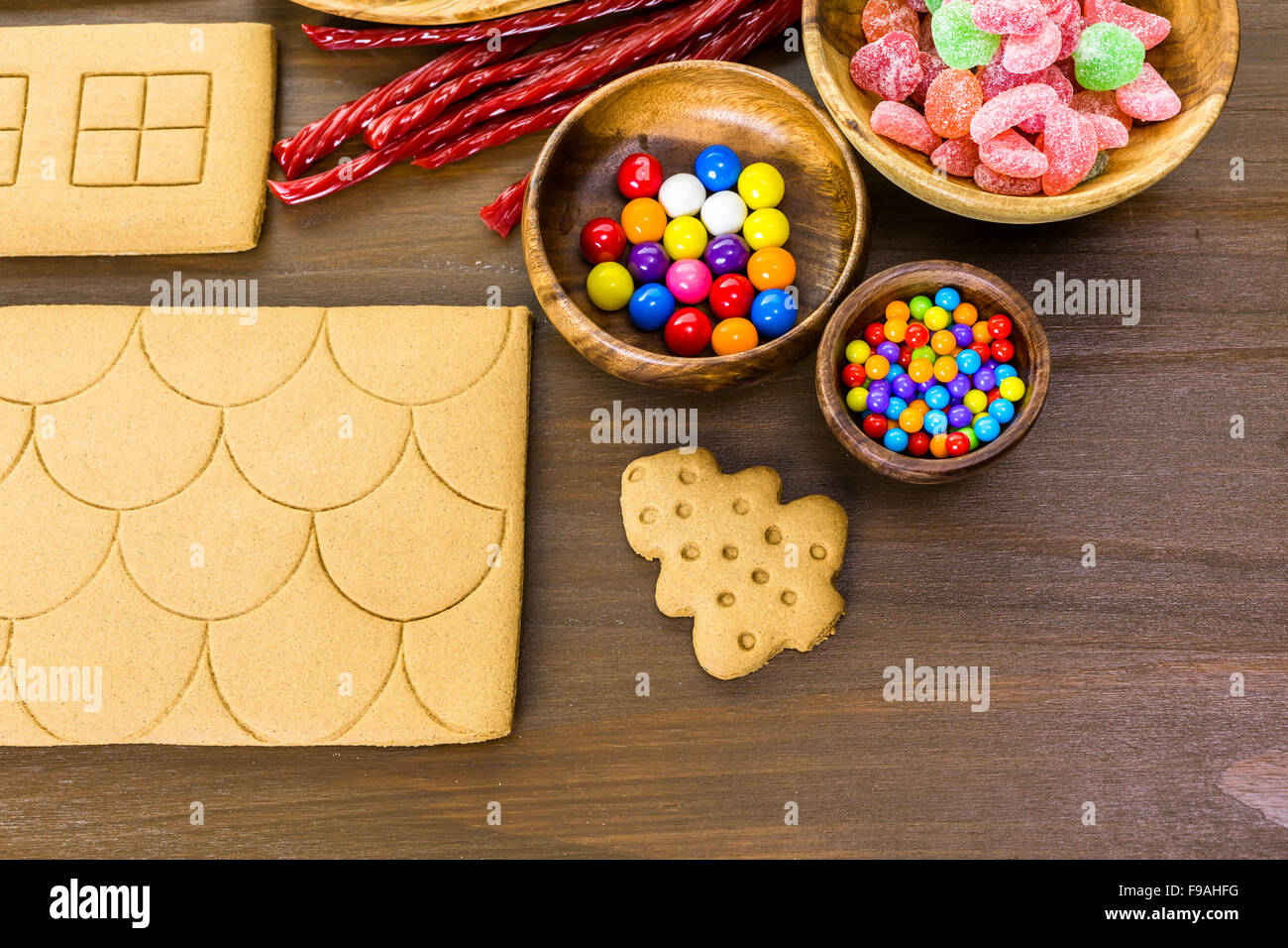 Decorating gingerbread house with royal icing and colorful candies ...