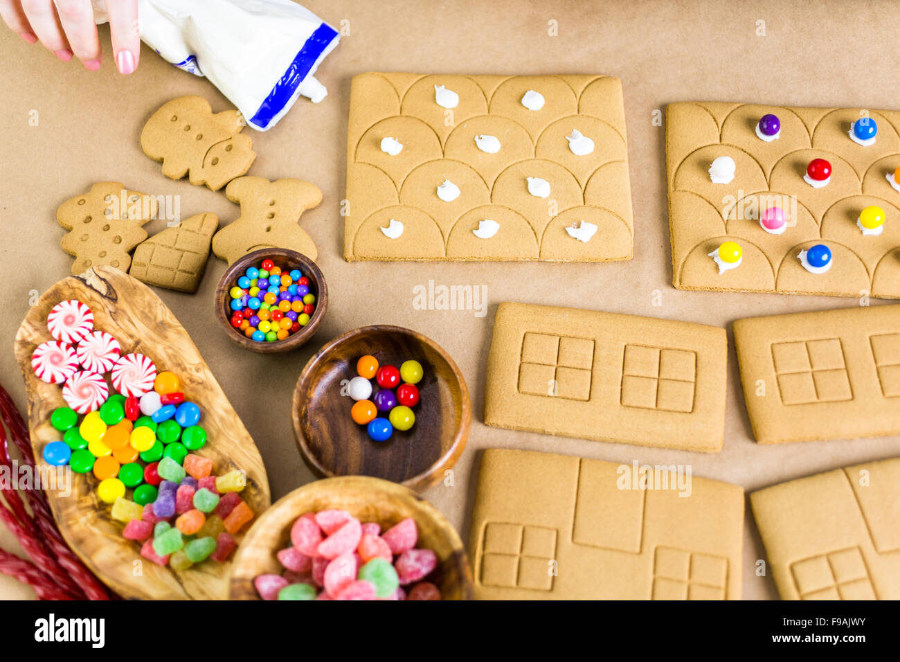 Decorating gingerbread house with royal icing and colorful candies ...