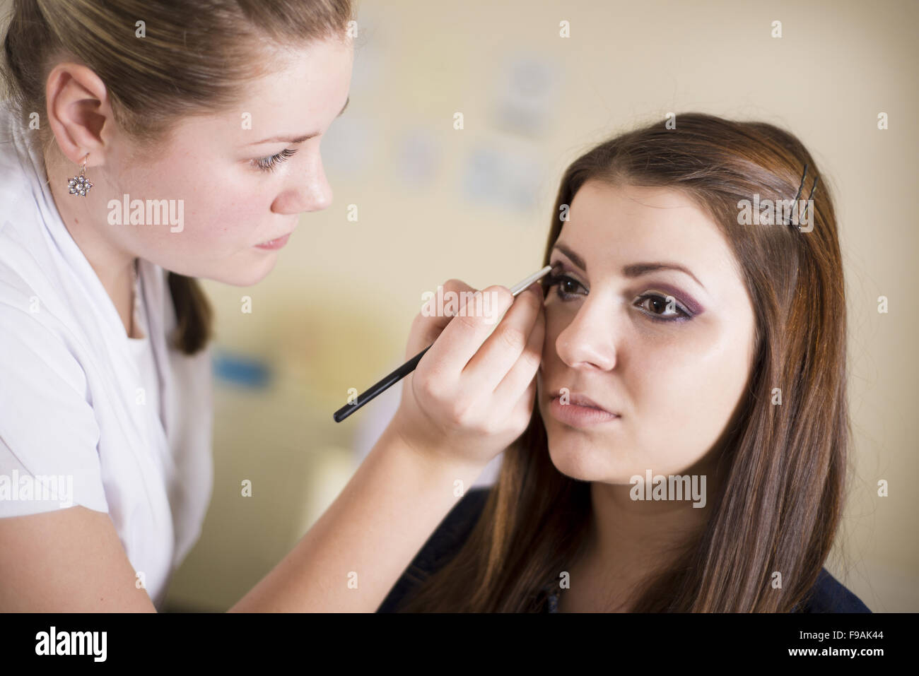Beautician doing professional make up of young woman Stock Photo - Alamy