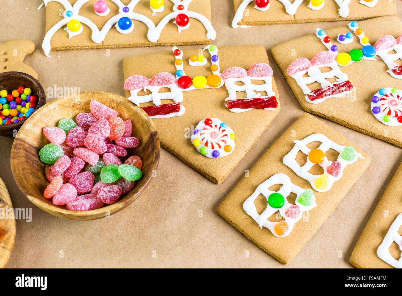 Decorating gingerbread house with royal icing and colorful candies ...