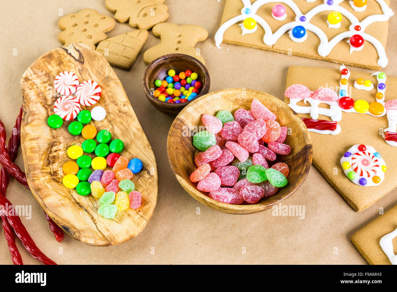 Decorating gingerbread house with royal icing and colorful candies ...