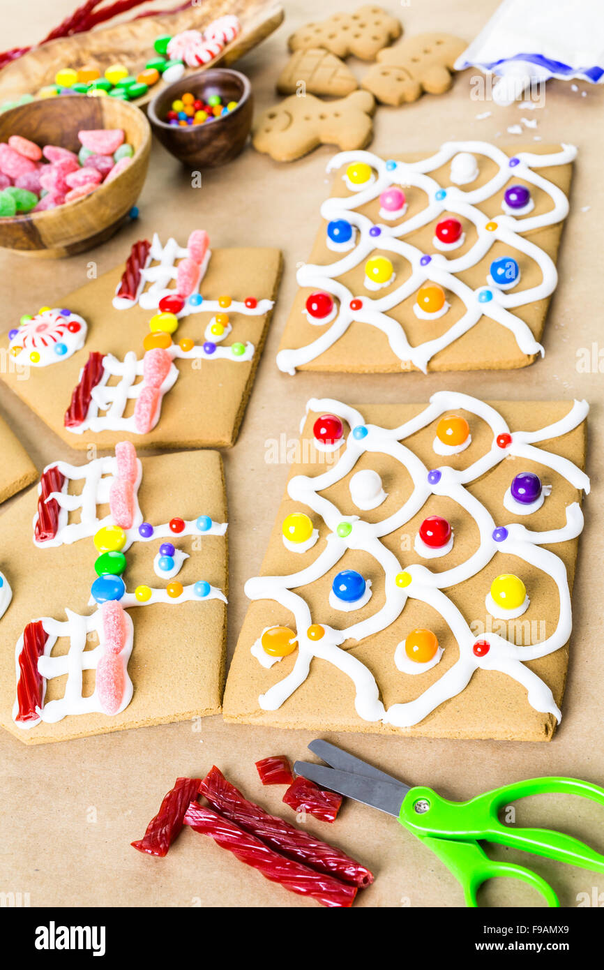 Decorating gingerbread house with royal icing and colorful candies ...