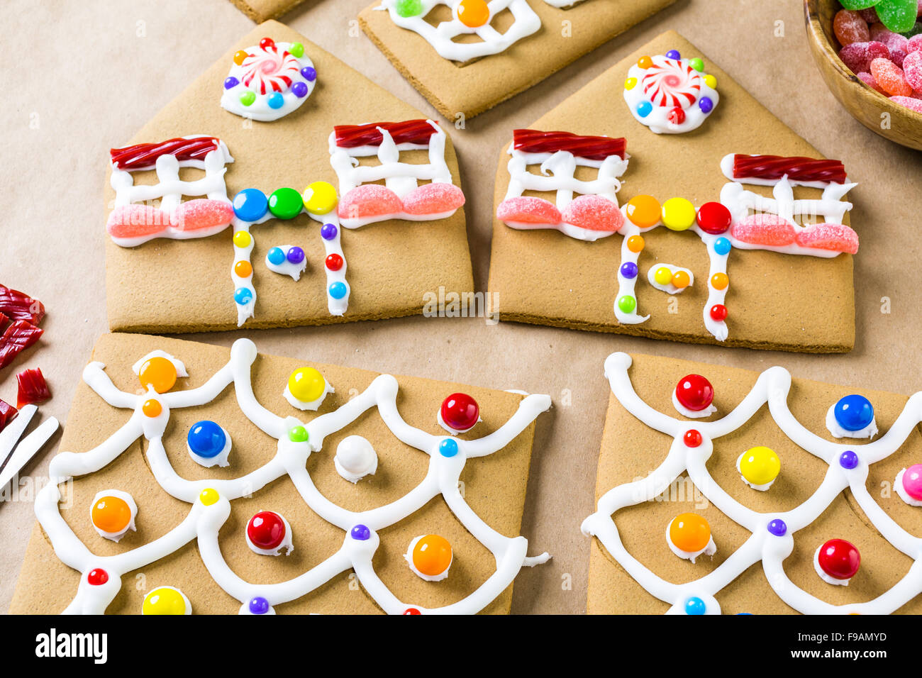 Decorating gingerbread house with royal icing and colorful candies ...