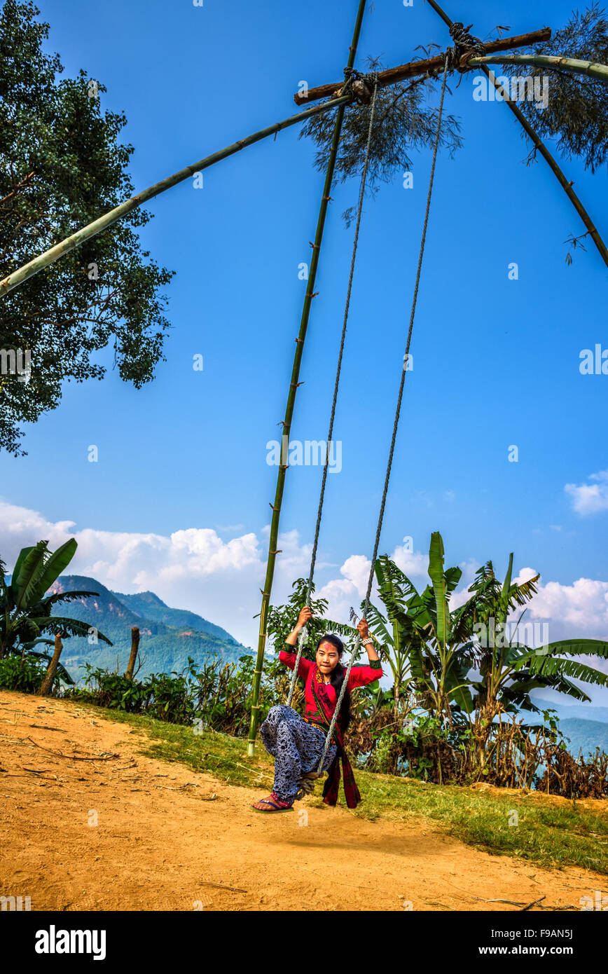 Nepalese girl playing on a traditional bamboo swing called linge ping ...
