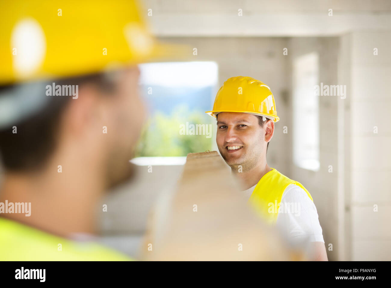 Construction workers collaborating on new house building Stock Photo ...
