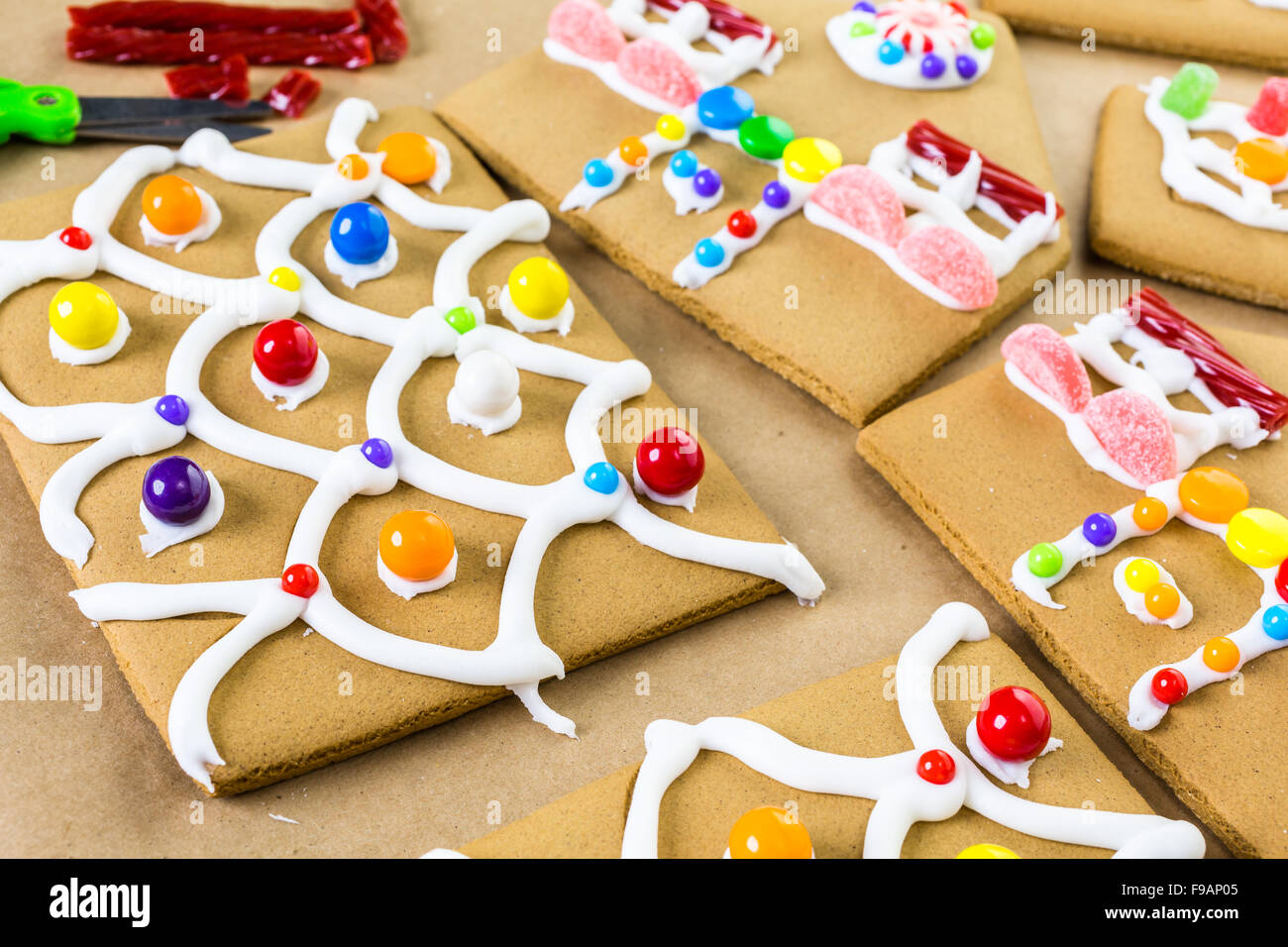 Decorating gingerbread house with royal icing and colorful candies ...