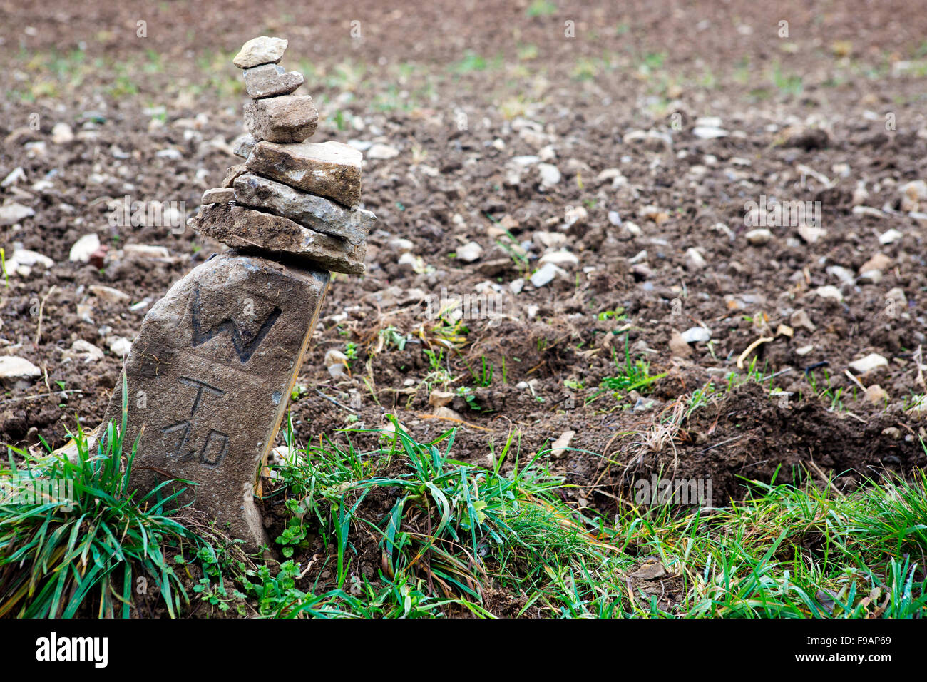 boundary stone at a cultivated brown field Stock Photo - Alamy