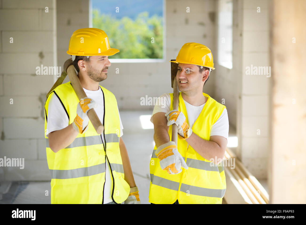 Construction workers collaborating on new house building Stock Photo ...