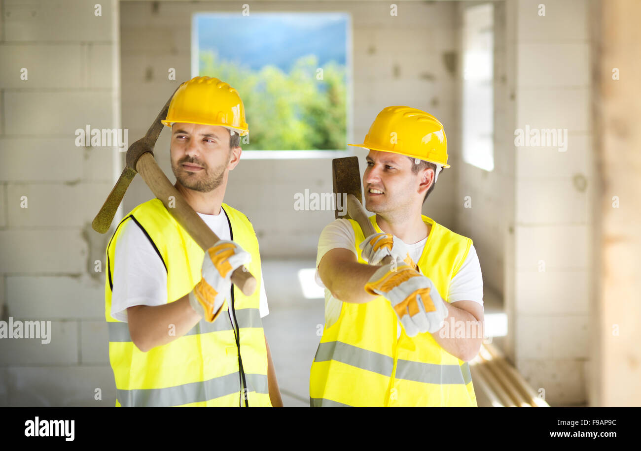 Construction workers collaborating on new house building Stock Photo ...