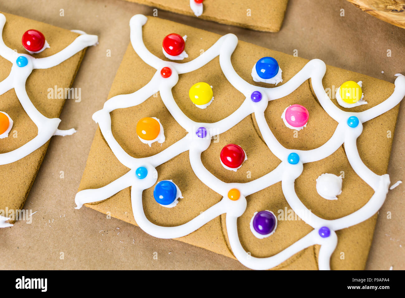 Decorating gingerbread house with royal icing and colorful candies ...