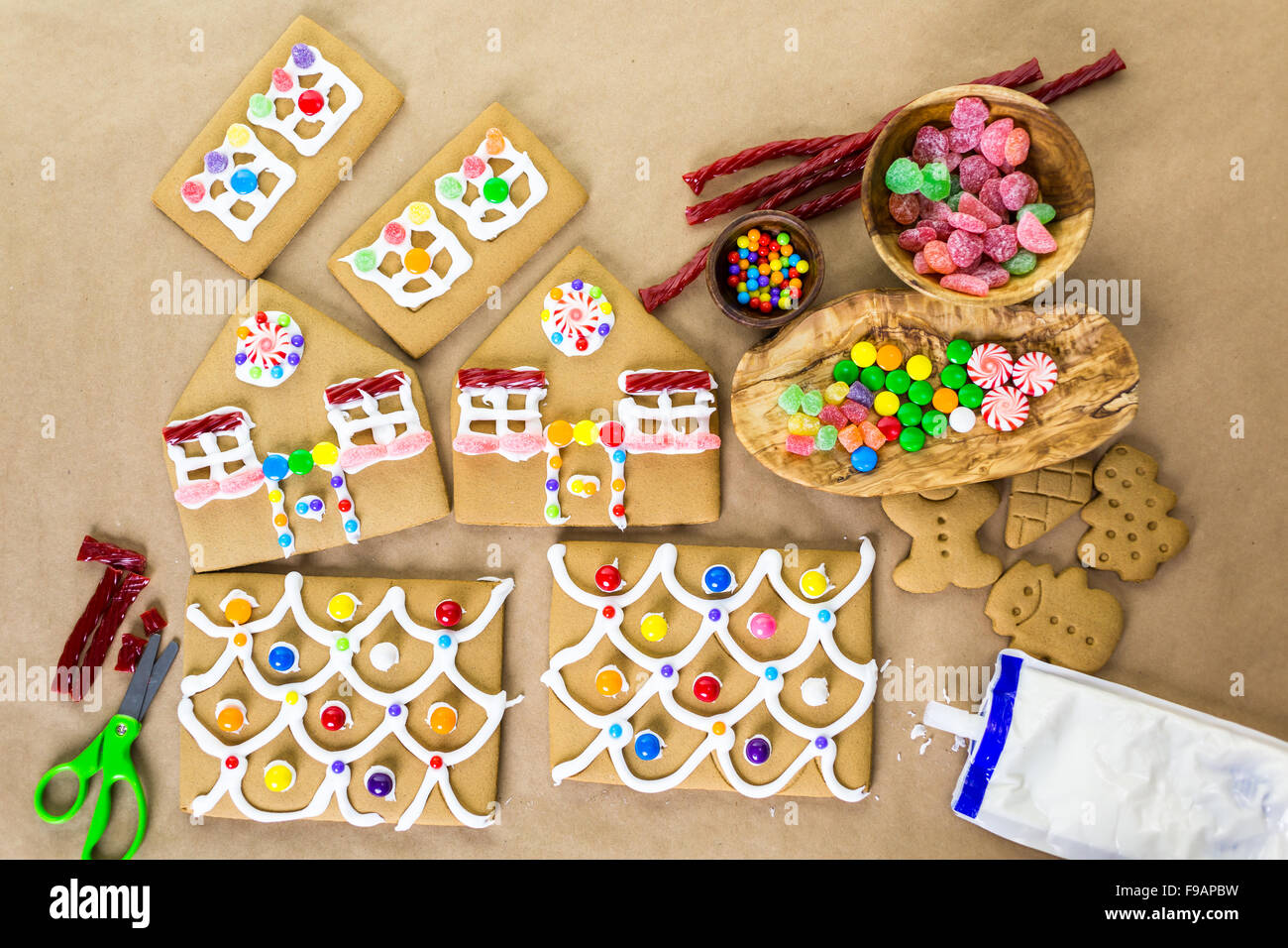 Decorating gingerbread house with royal icing and colorful candies ...