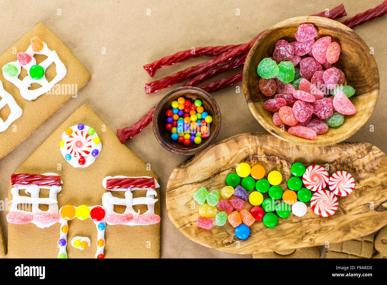 Decorating gingerbread house with royal icing and colorful candies ...