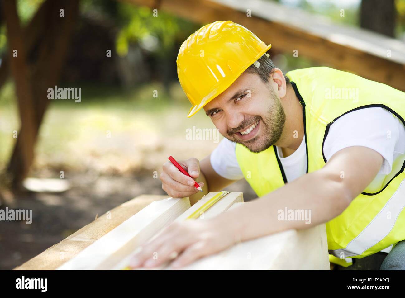Construction worker is working with wooden beam Stock Photo - Alamy
