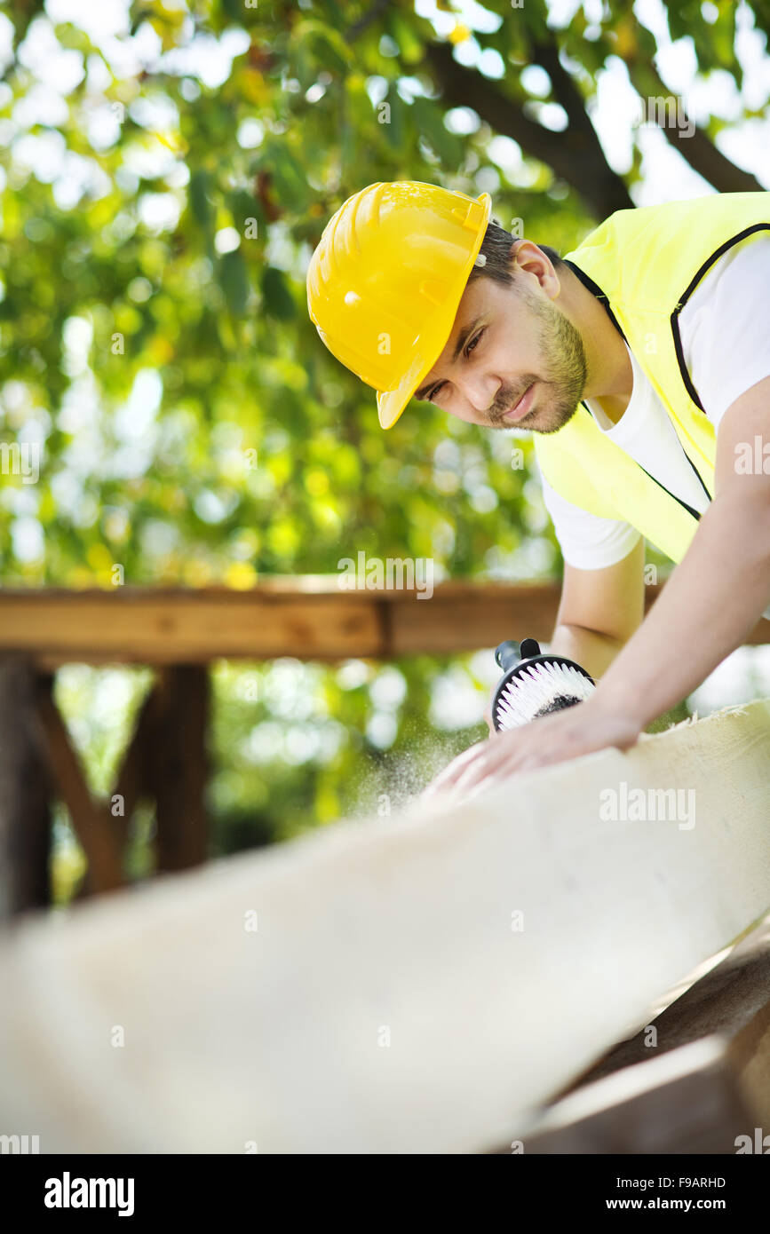 Construction worker is working with wooden beam Stock Photo - Alamy