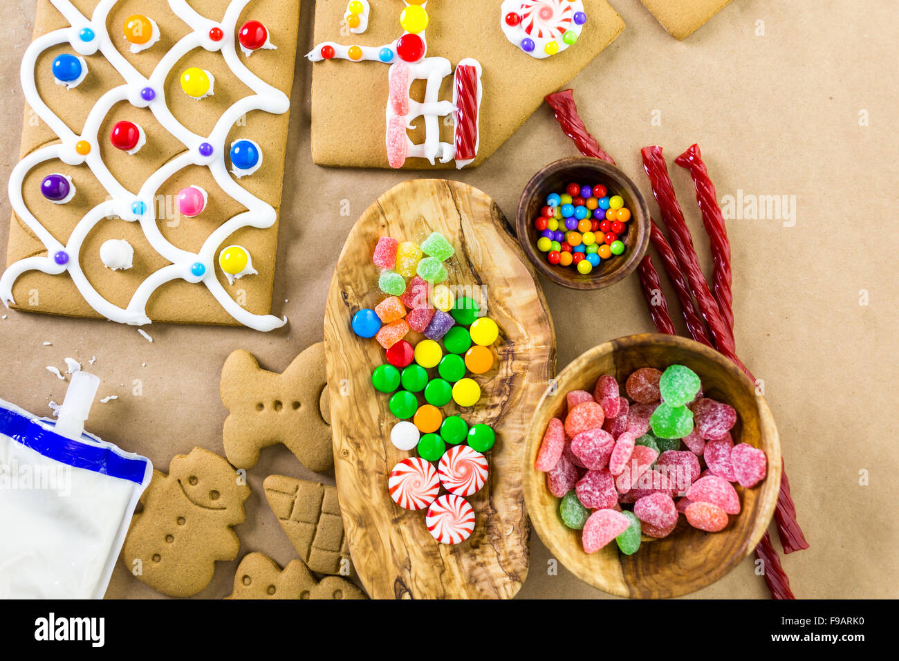 Decorating gingerbread house with royal icing and colorful candies ...