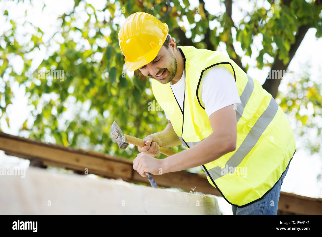 Construction worker is working with wooden beam Stock Photo - Alamy