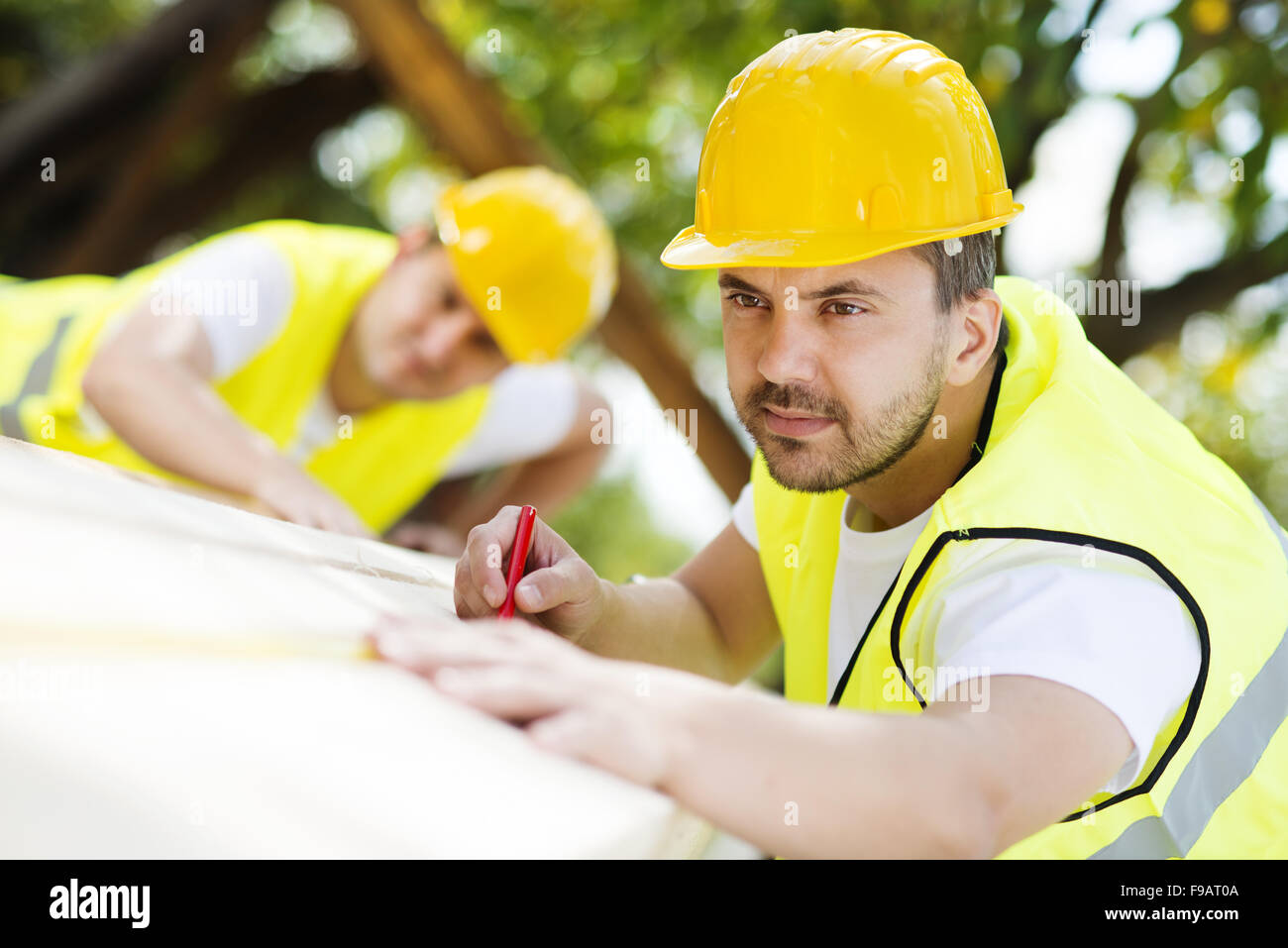 Construction workers collaborating on new house building Stock Photo ...