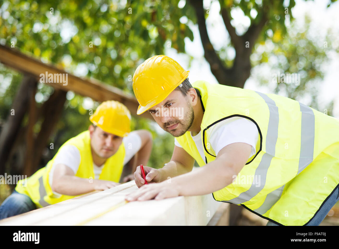 Construction workers collaborating on new house building Stock Photo ...