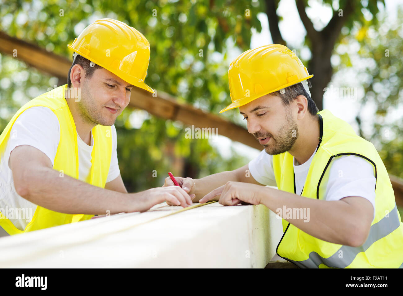 Construction workers collaborating on new house building Stock Photo ...